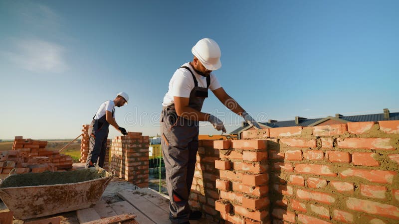 Multiracial Builders Laying Bricks for a Modern Wall Stock Video ...