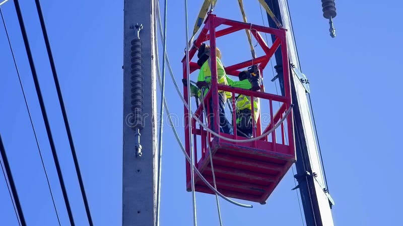 Two Skilled Workers on a Lift are Ensuring Safety during Electrical ...
