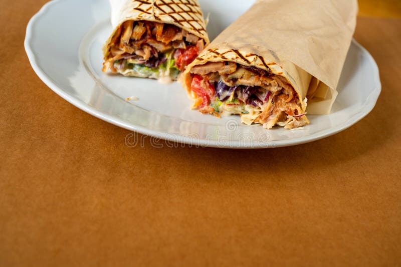 Two Sliced Piece of Wrapped Kebab on Plate on Table Stock Photo - Image ...