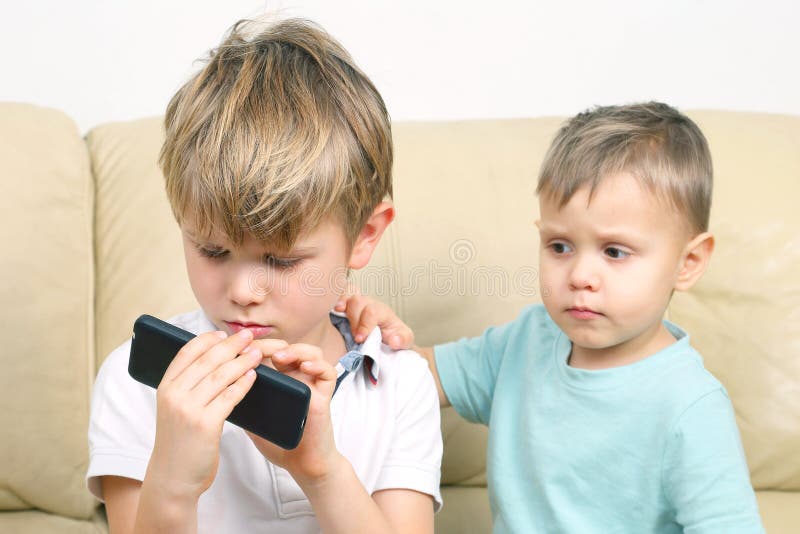 Two Small Boys Looking at Cell Phone Stock Image - Image of indoors ...