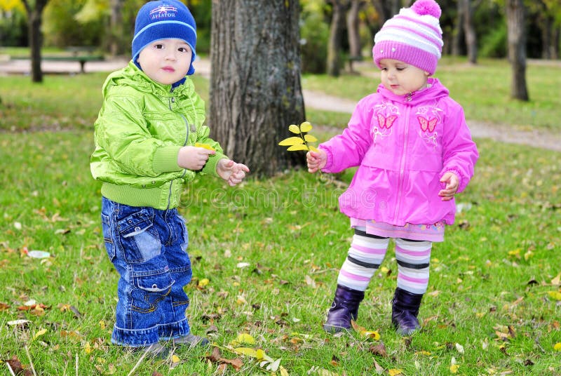 Two Small Children Sit on a Green Clearing Stock Image - Image of leaf ...