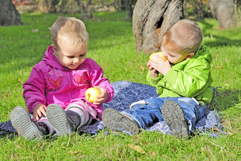 Two Small Children Sit on a Green Clearing Stock Photo - Image of child ...
