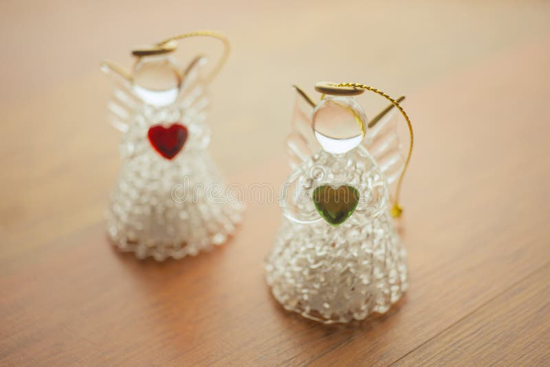 Two Small Glass Statues of Angels with Hearts on the Table Stock Image ...