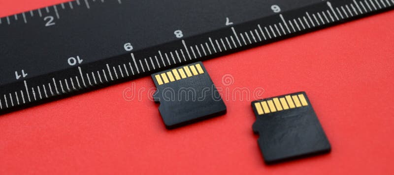 Two Small Micro SD Memory Cards Lie On A Red Background Next To A Black ...