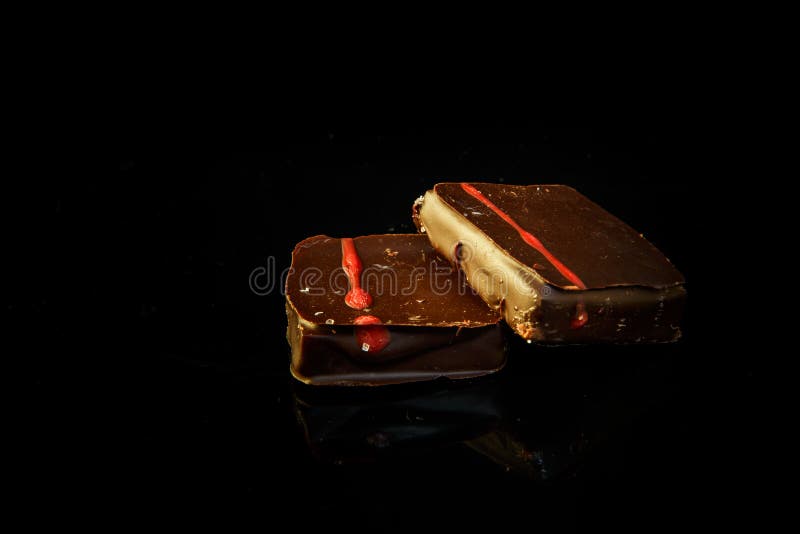 Two Small Square Chocolate Candies on Black Background Stock Photo ...