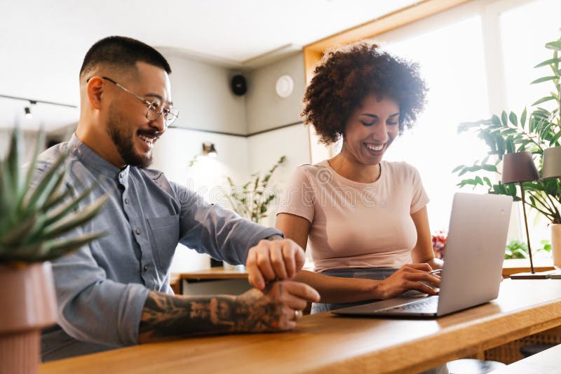 Two Smiling Business Owners Using Laptop while Working in Cafe Stock ...