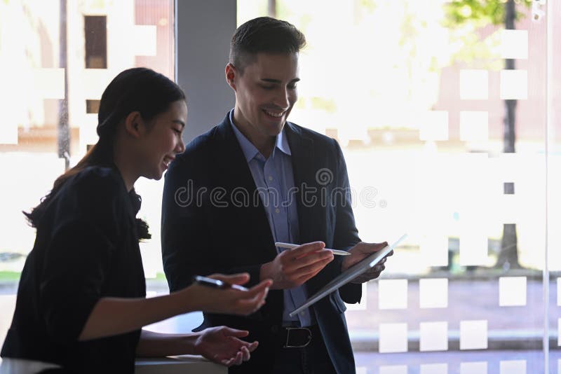 Two Business People Analyzing Online Data Together on Digital Tablet ...
