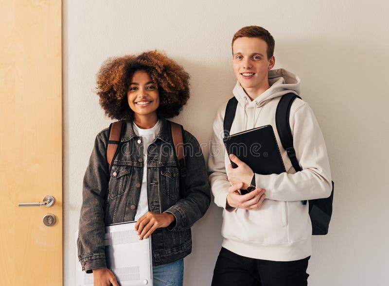 Two Smiling Classmates Standing Together at Wall and Looking at Camera ...