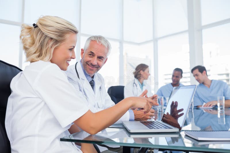 Two Smiling Doctors Looking at a Laptop Stock Photo - Image of ...