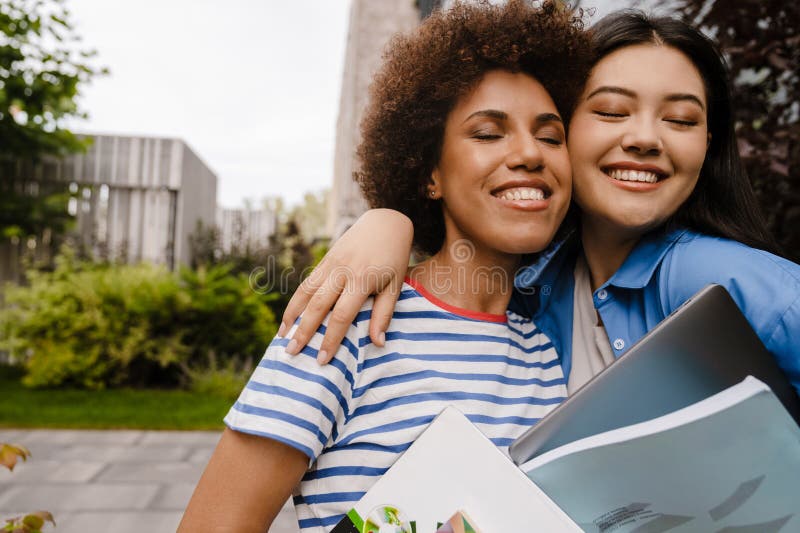 Two Smiling Female Students Hugging while Standing in Campus Stock ...