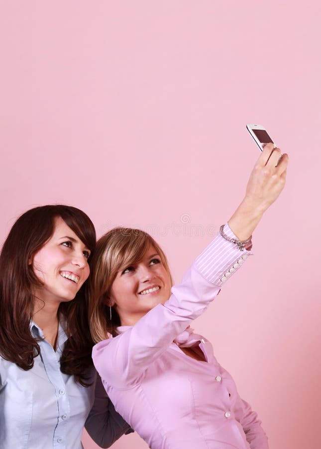 Two Smiling Friends Using Cell Phone for a Photo Stock Image - Image of ...