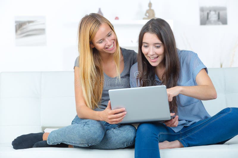 Two Smiling Girlfriends Sitting on Sofa and Doing Homework Stock Image ...