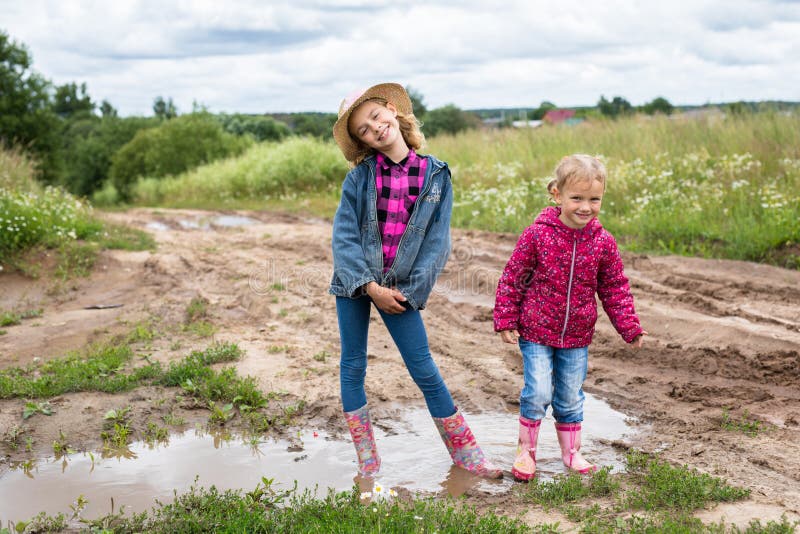 Two Girls Run through the Puddles and Play. Stock Image - Image of ...