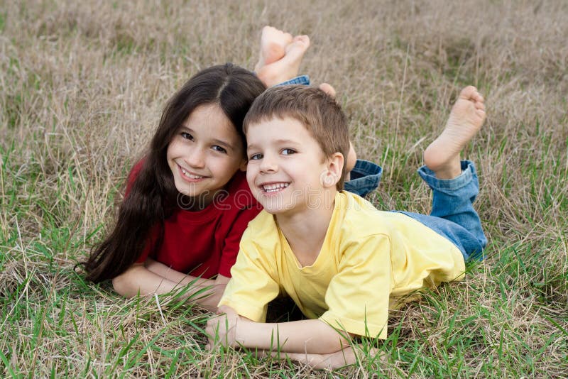 Two Smiling Kids on the Autumn Grass Stock Photo - Image of green ...