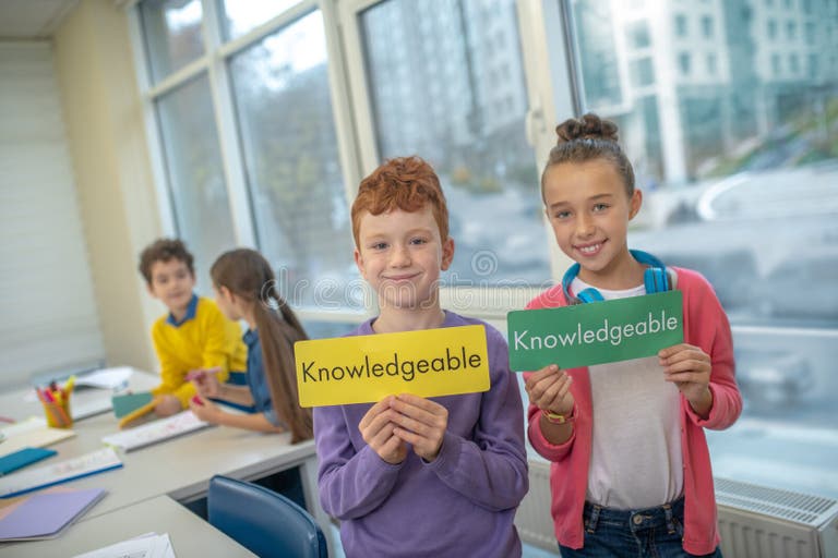 Two Smiling Kids Holding the Word Knowledgeable Stock Photo - Image of ...