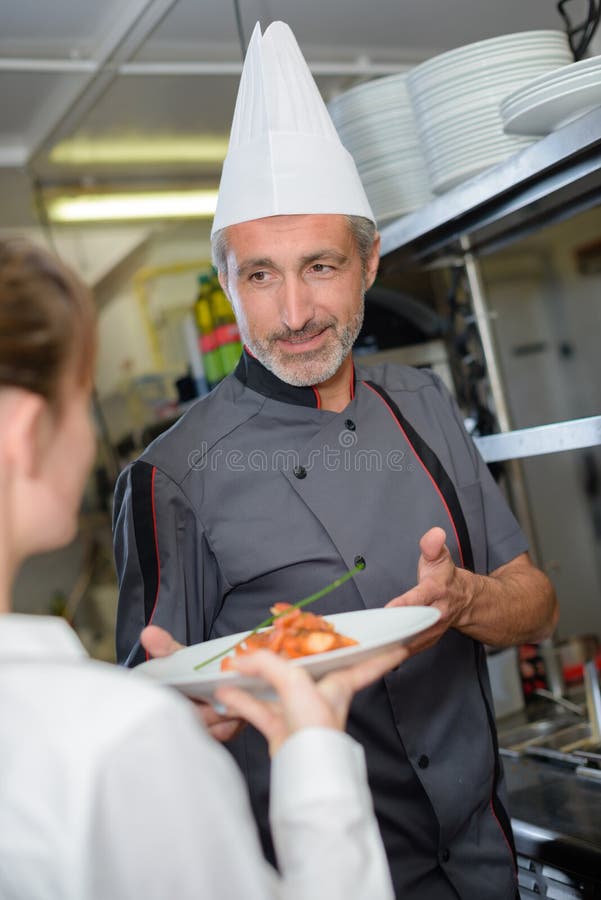Two Smiling Professional Cooks Working at Restaurant Kitchen Together ...