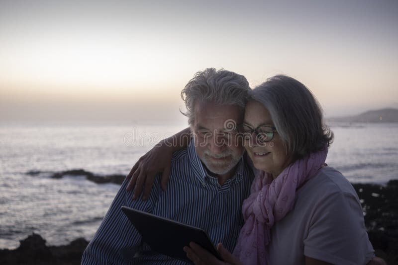 Two Smiling Senior People Watching the Computer Together while the ...