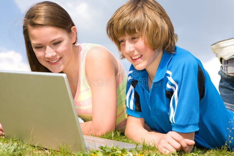 Two Smiling Teenagers with Laptop Stock Image - Image of meadow ...