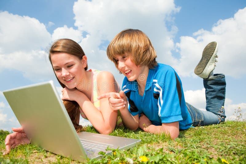 Two Smiling Teenagers with Laptop Stock Image - Image of meadow ...