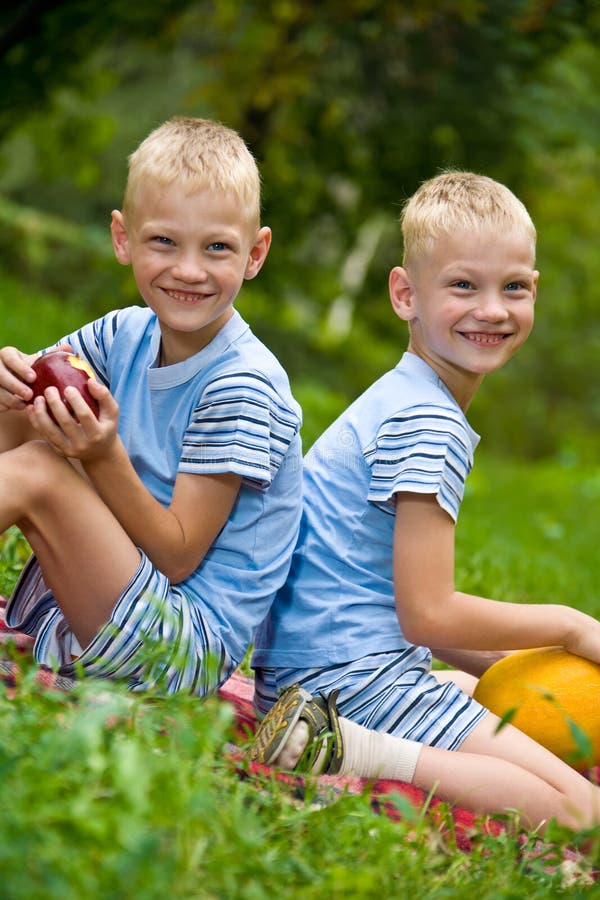 Two Smiling Twin Brothers Holding Fruits Stock Photo - Image of ...