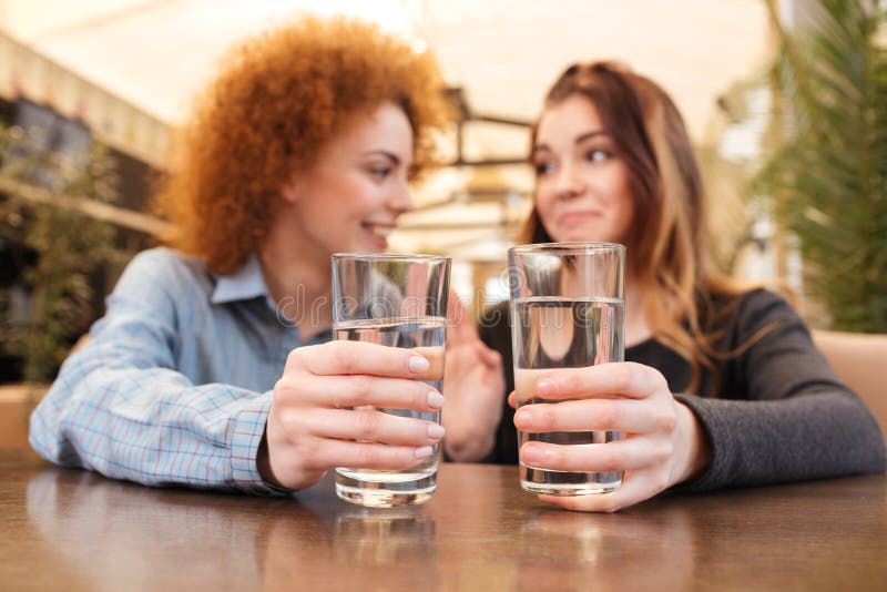 Two Smiling Women Drinking Water at the Table in Cafe Stock Image ...