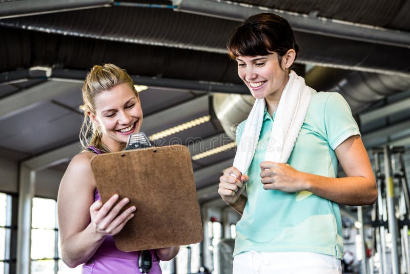 Two Smiling Women Looking at Notes Stock Photo - Image of indoors ...