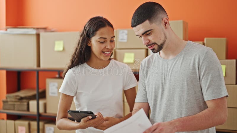 Two Smiling Workers, a Man and a Woman, Reading a Document Together on ...