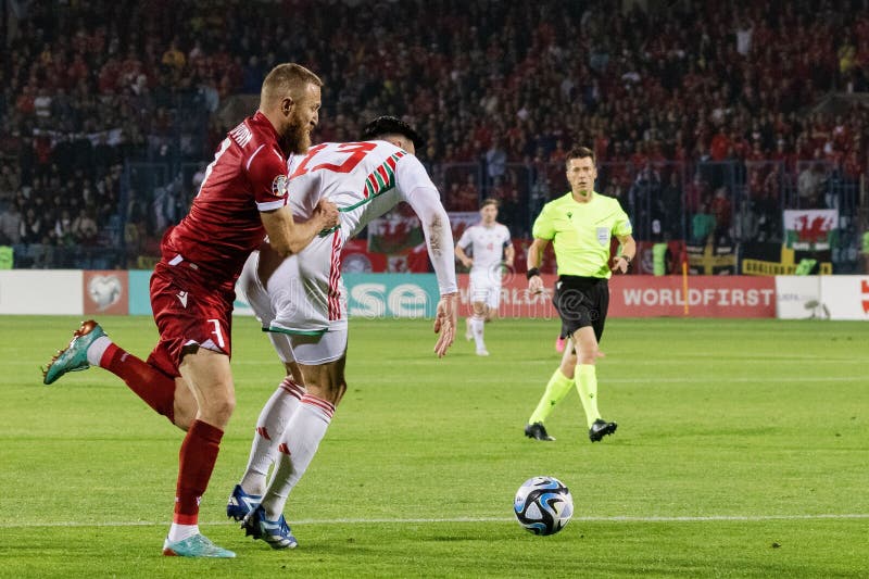 Two Soccer Players Chasing a Ball on the Field during a Match Editorial ...
