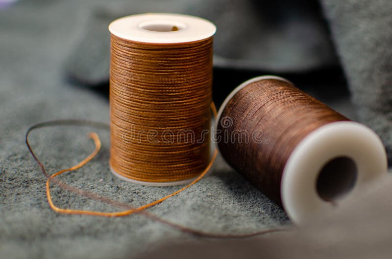 Two Spools of Brown Thread on a Black Inverted Leather Background Stock ...