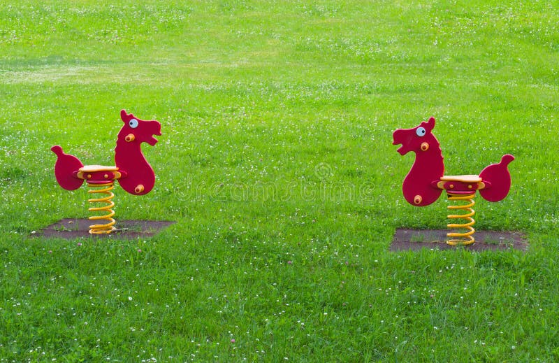 Two Spring Horse Toy Surrounded by Grass in a Playground Stock Photo ...