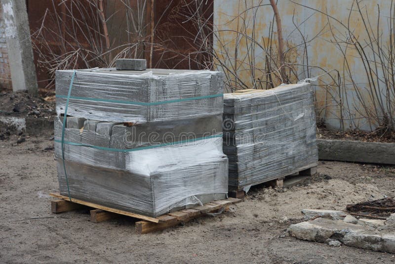 Two Square Boxes in Plastic Packaging with Paving Bricks Stock Photo ...