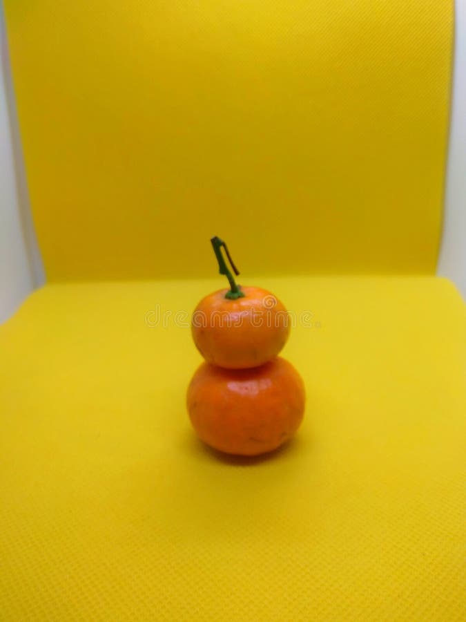 Two Stacked Orange Fruit Objects on a Yellow Background Looks Fresh ...