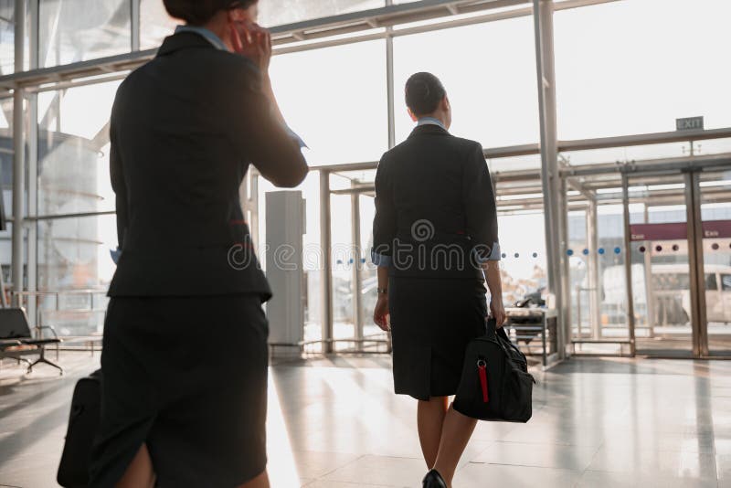 Two Stewardesses Walking To the Airport Terminal Exit Stock Image ...