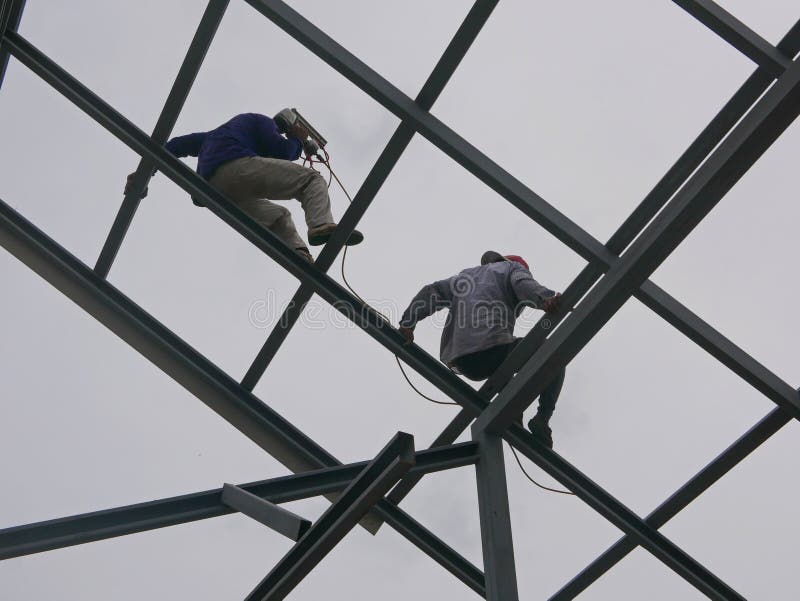 Two Structural Steel Workers Working on a High Rooftop for a House Roof ...