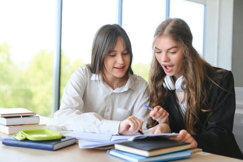 Two Students Doing Homework Together and Helping Each Other Sitting in ...