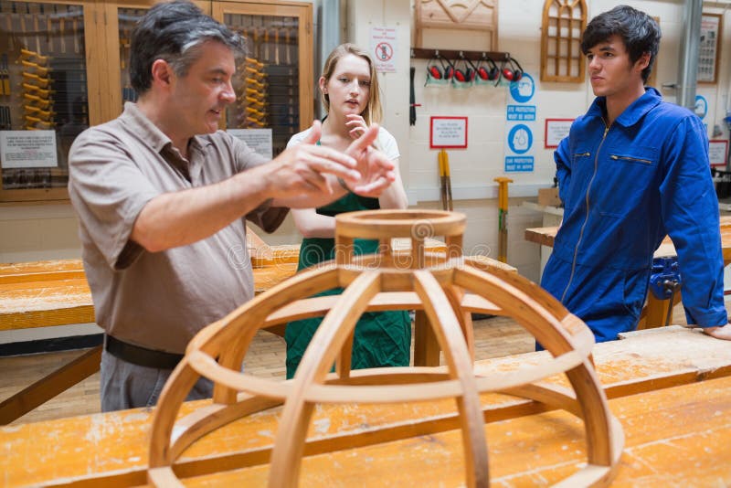 Two Students and an Explaining Teacher in a Woodwork Class Stock Photo ...