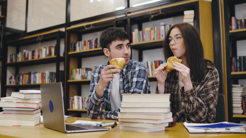 Students Enjoying Pastries while Studying in a Cozy Library Setting ...