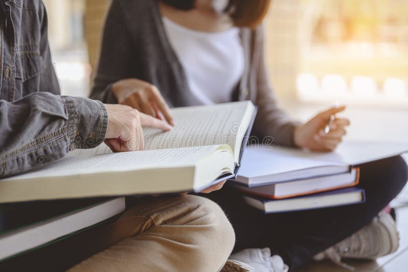 Two Students are Sitting on the Floor Reading Books To Education. Study ...