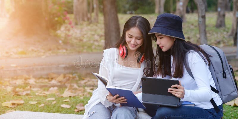 Two Students are Sitting in Park during Reading a Book and ...