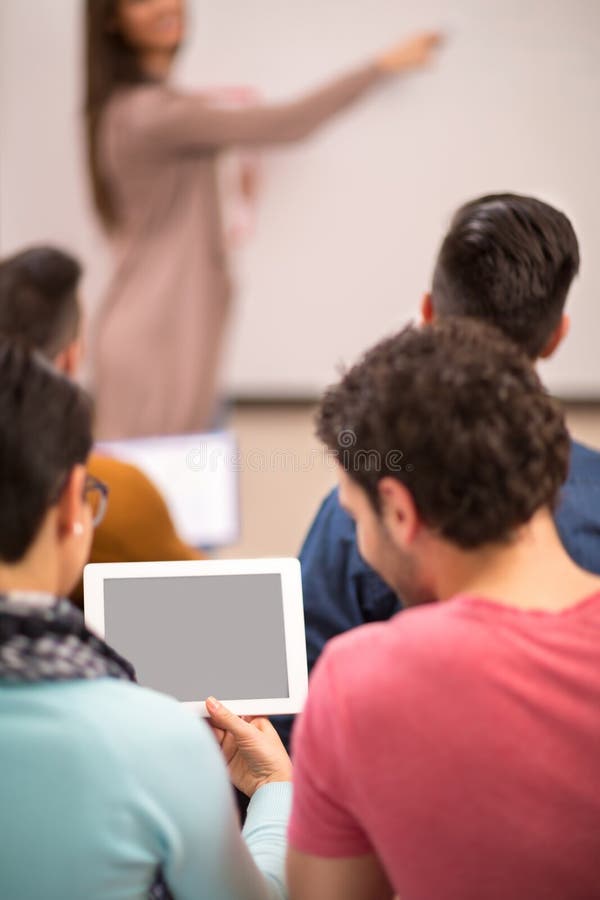 Two Students Watching Tablet while Professor Giving Lecture Stock Photo ...