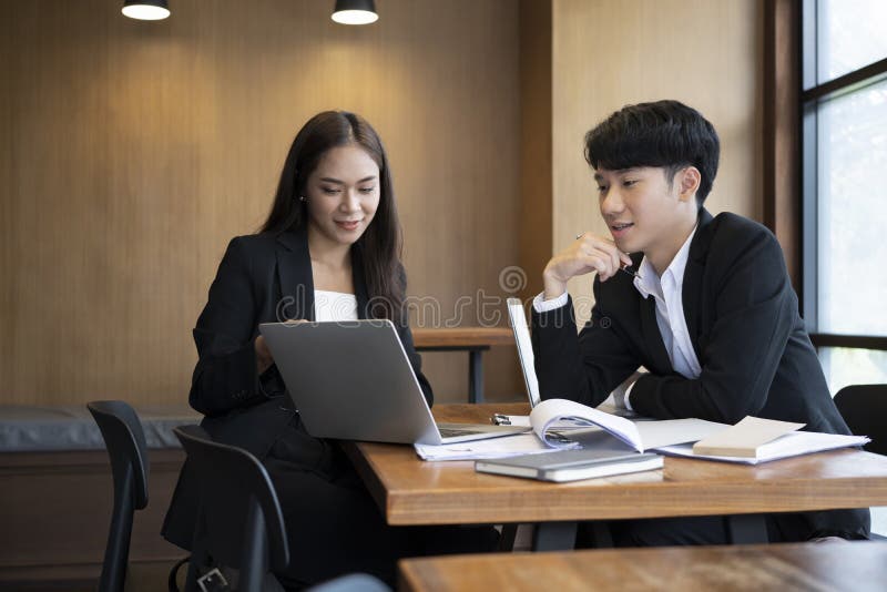 Two Businesspeople Analyzing Statistical Graph Together on Laptop ... Two Businesspeople Analyzing Statistical Graph Together on Laptop ...