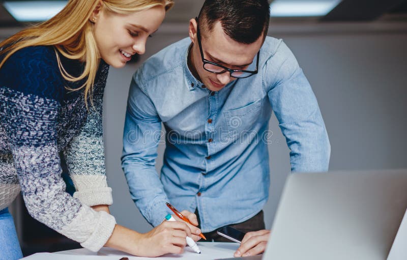 Two Successful Designers Working Together on Common Project at Table Wit Modern Laptop Computer ...
