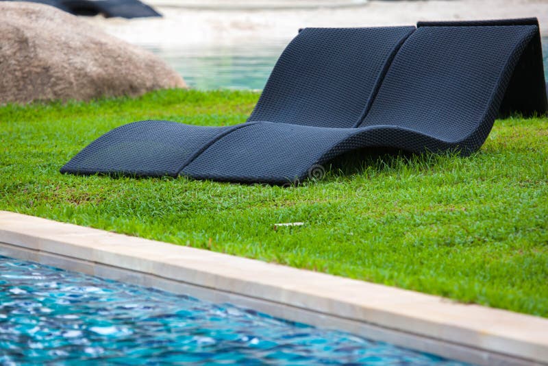 Sunbeds near swimming pool stock photo. Image of outdoor - 180676902