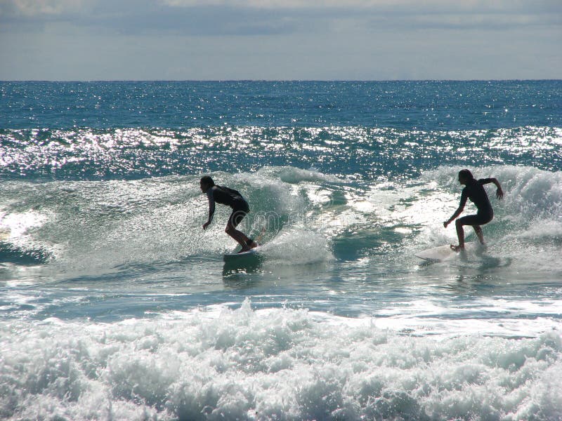 Two Surfers Riding A Wave. Editorial Stock Photo - Image: 27410663 Two Surfers Riding A Wave. Editorial Stock Photo - Image: 27410663