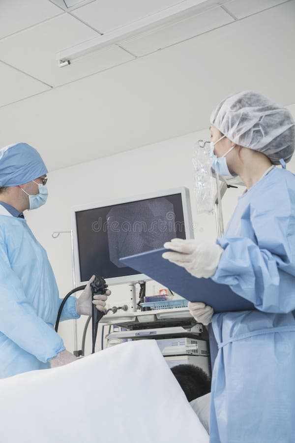 Two Surgeons Preparing for Surgery, Patient Lying Down Stock Photo ...