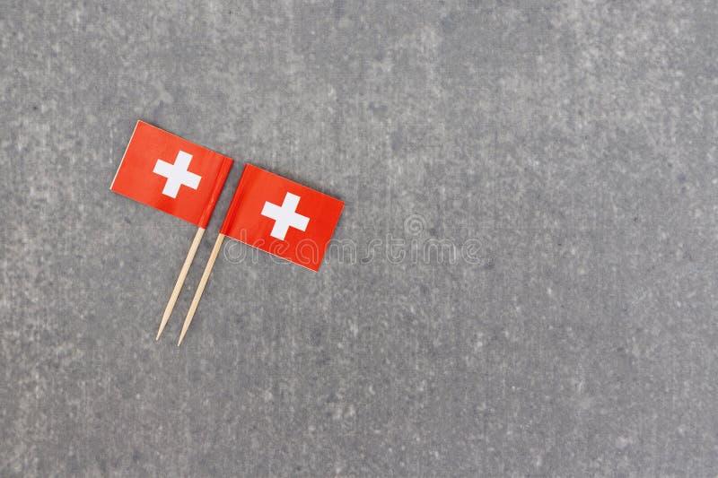 Two Swiss Flags Aligned Left on Gray Background with Blank Space for ...