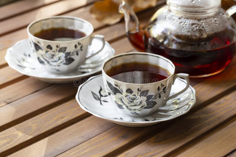 Two Tea Cups with Tea and Teapot at Wood Background Stock Photo - Image ...