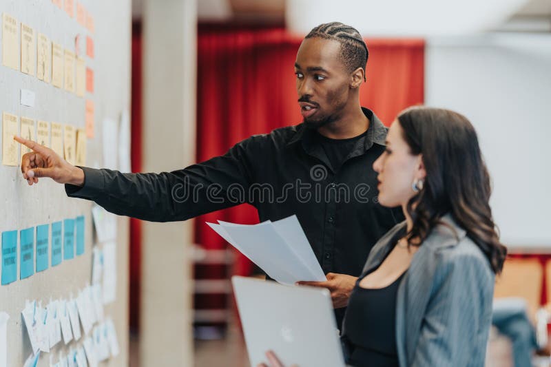 Two Business People Collaborating on a Team Project Plan Using a Board ...