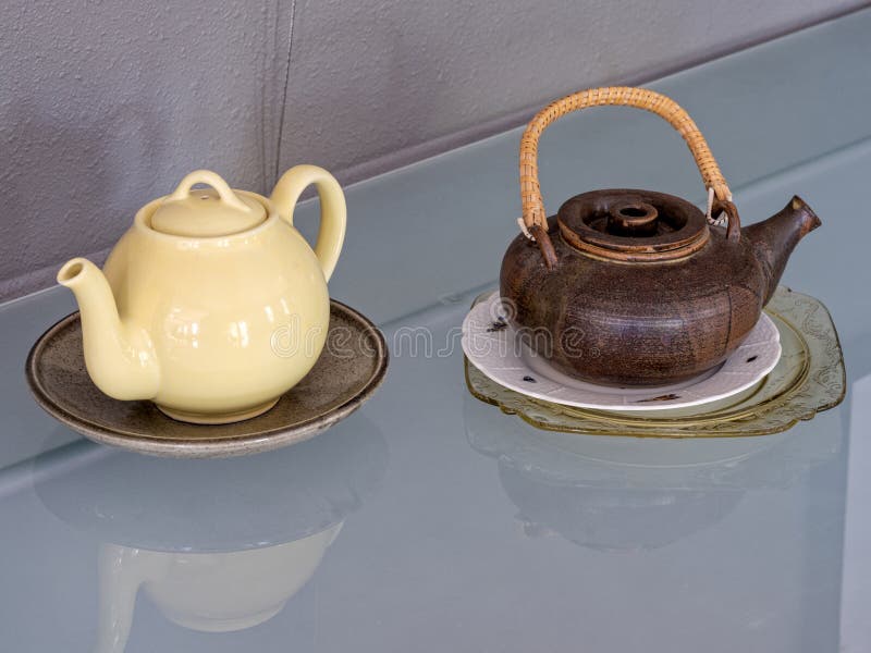 Two Teapots in Saucers on a Glass Table Stock Image - Image of room ...