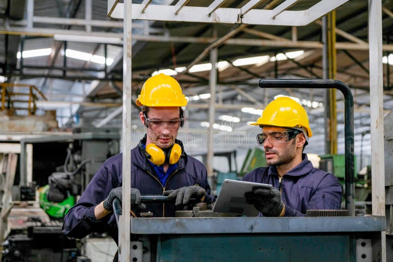 Two Technician Men with Blue Uniform and Yellow Helmet Work with the ...